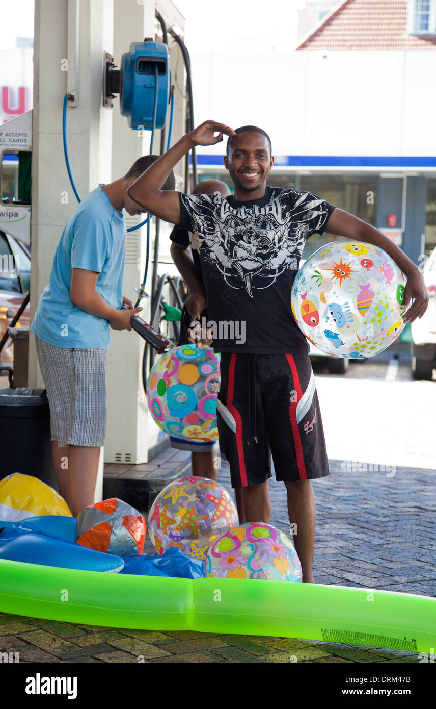 Group of Black Youths filling Inflatables with Air at garage in cape ...