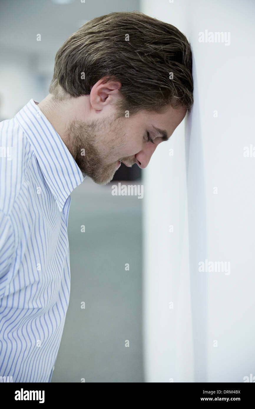 Business man leaning head to wall hi-res stock photography and images ...