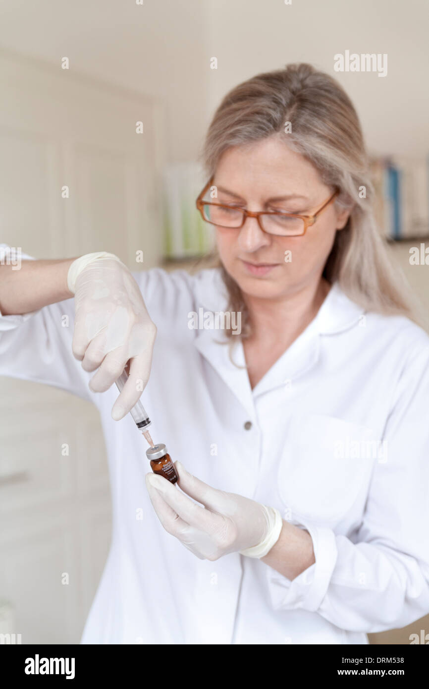Female alternative practitioner preparing injection syringe Stock Photo ...