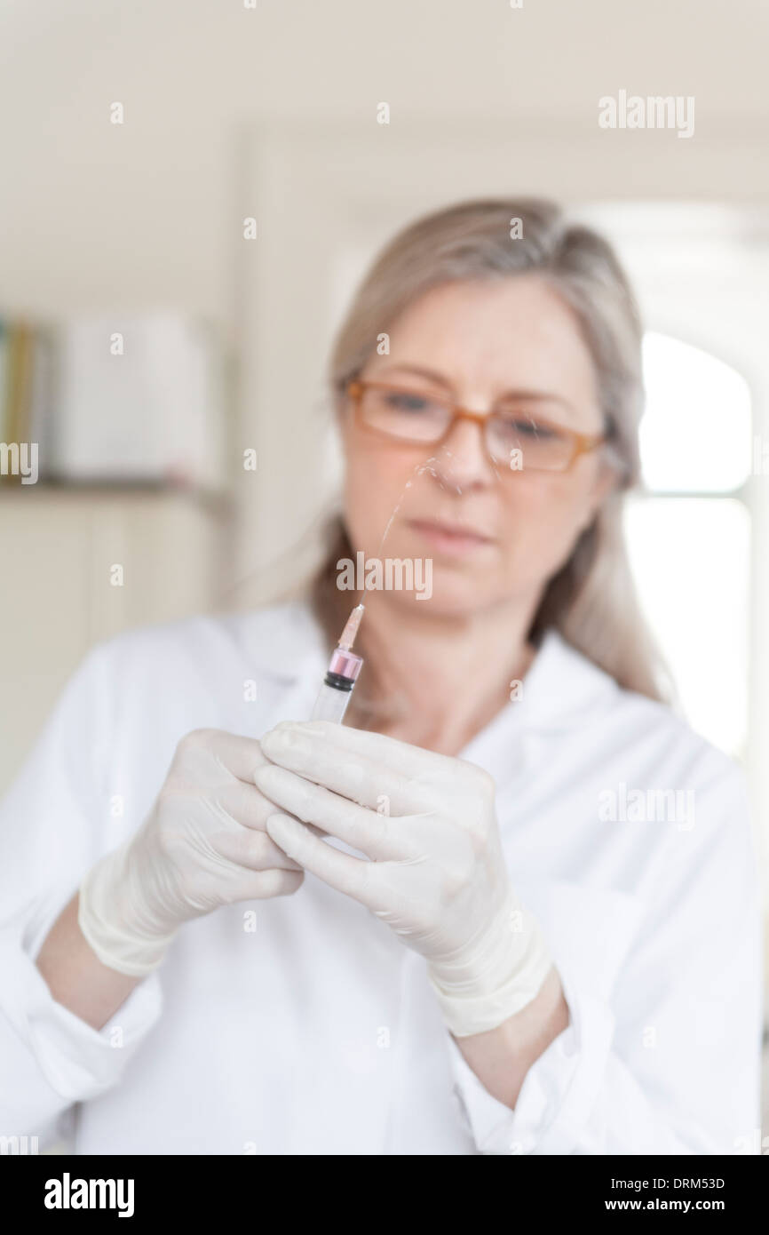 Female alternative practitioner preparing injection syringe Stock Photo ...
