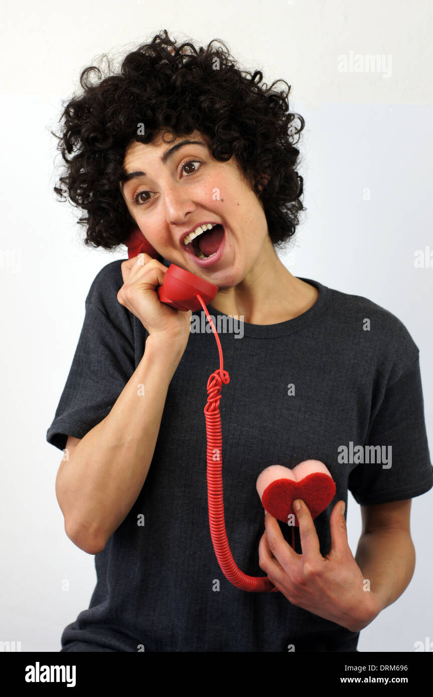 Woman talks on red phone Stock Photo - Alamy