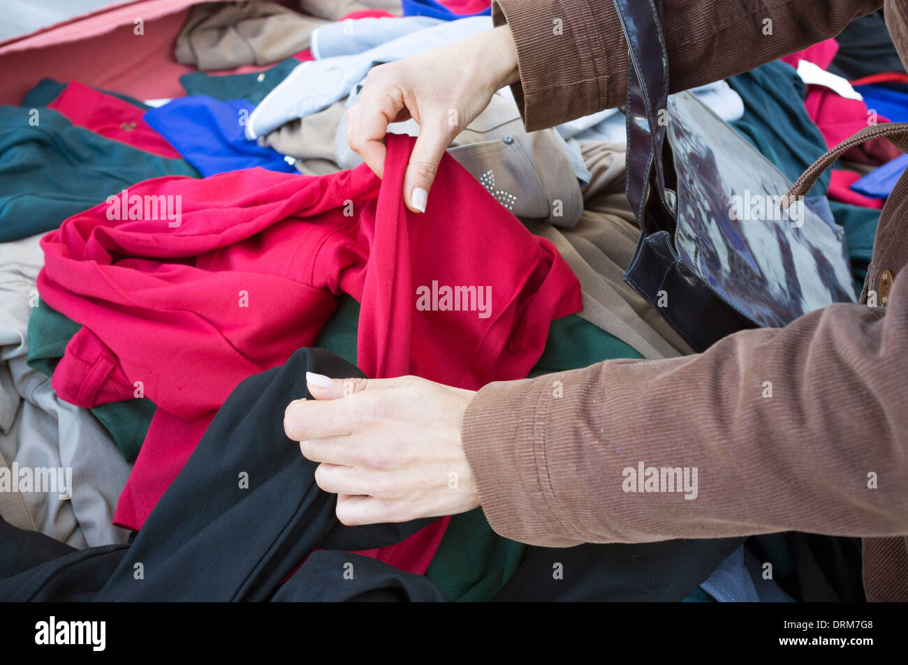 Female hands rummaging on a second hand clothes stall Stock Photo - Alamy