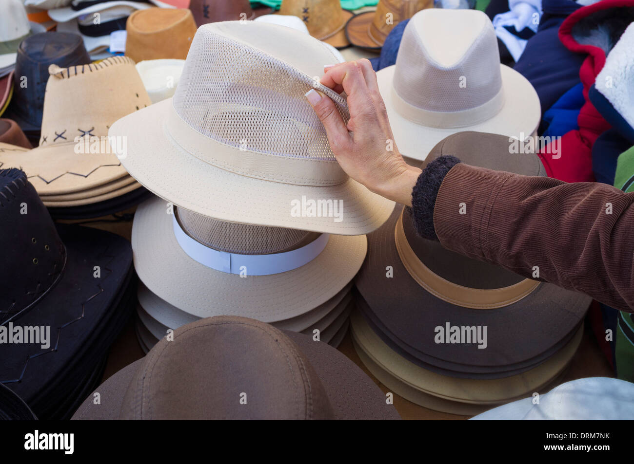 Female hands choosing a hat on a street market stall Stock Photo - Alamy