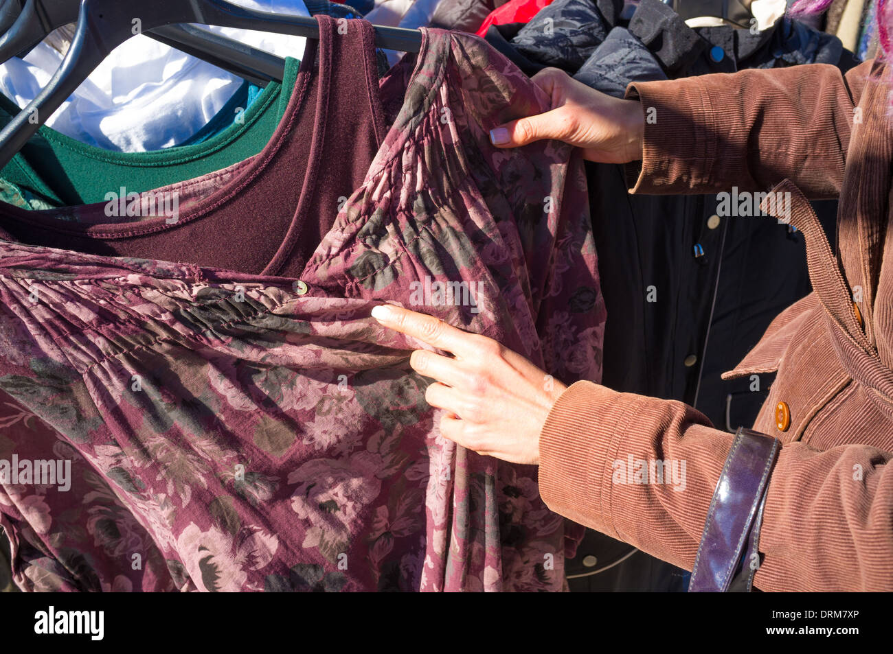 Female hands rummaging on a second hand clothes stall Stock Photo - Alamy