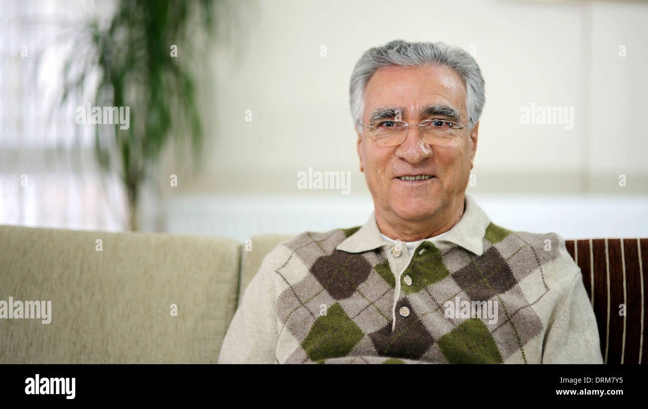 Senior man sitting on sofa Stock Photo - Alamy