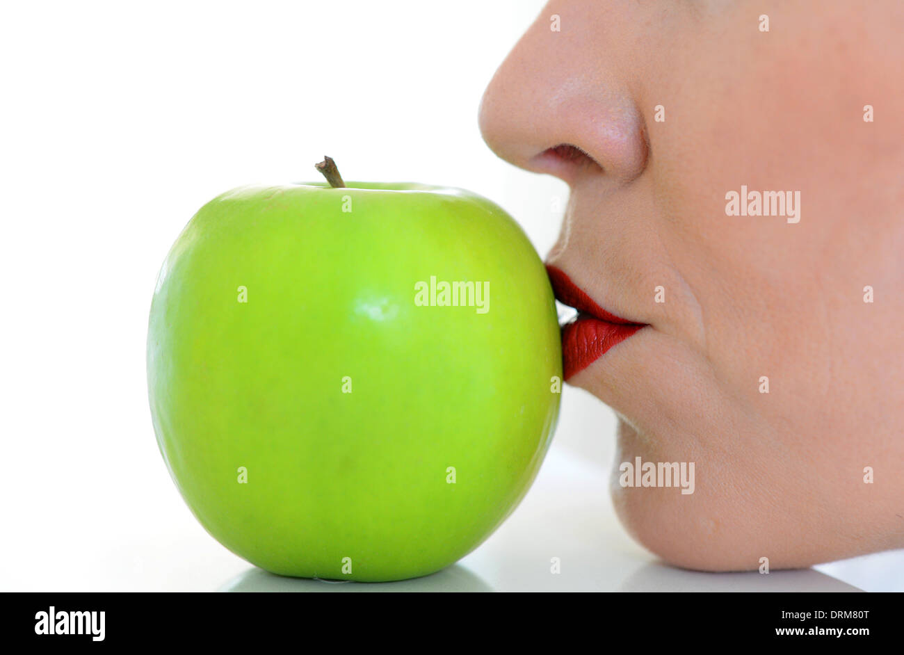 A woman kissing a green apple Stock Photo - Alamy
