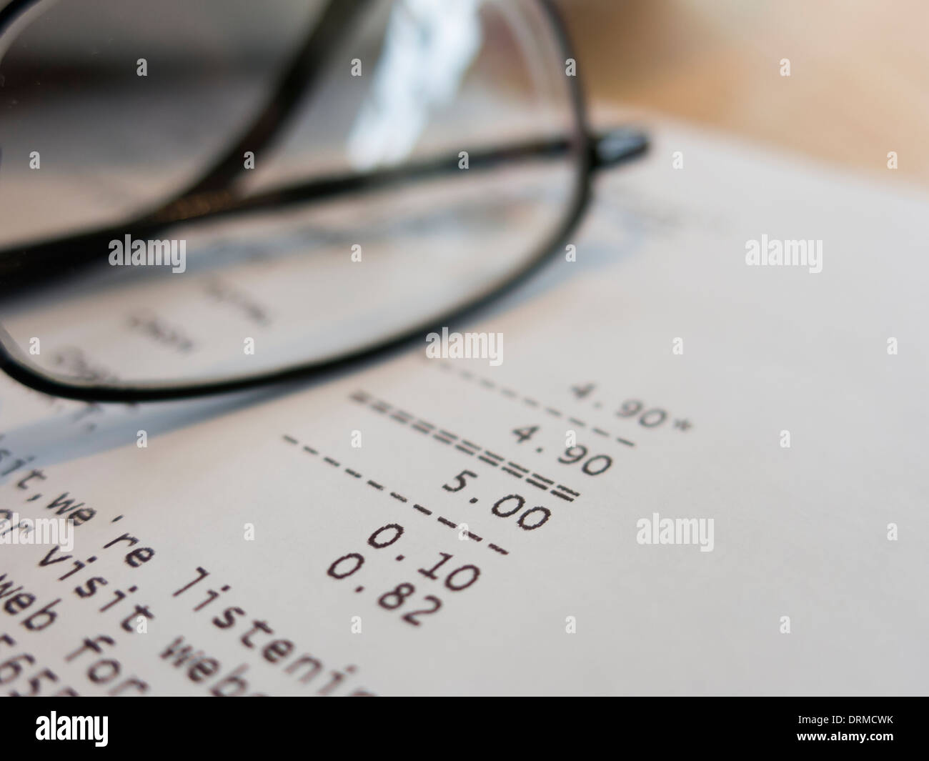 Glasses resting on printed bill/receipt close up Stock Photo - Alamy