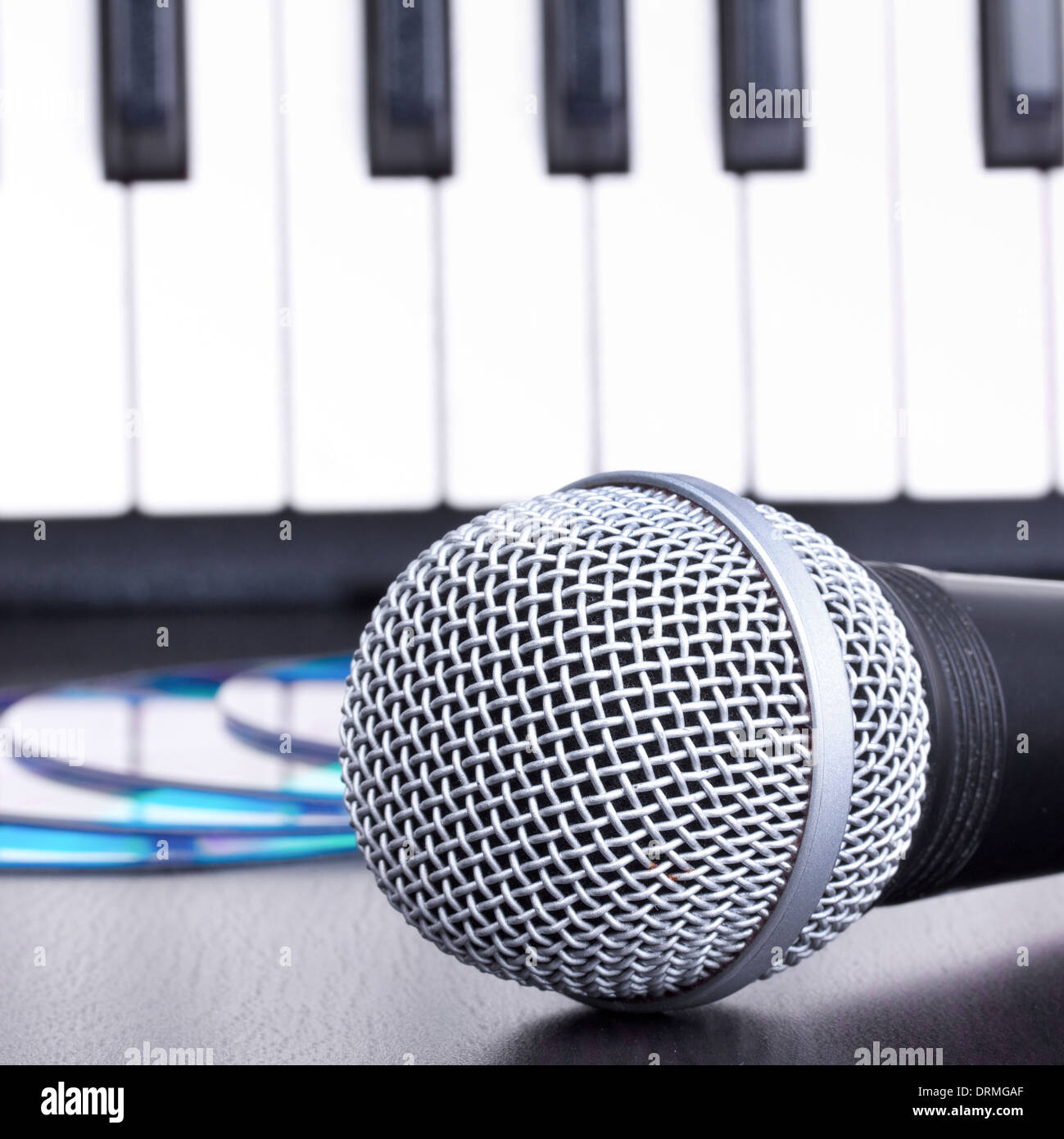 Microphone, cd disks and piano keyboard on black table,closeup Stock ...
