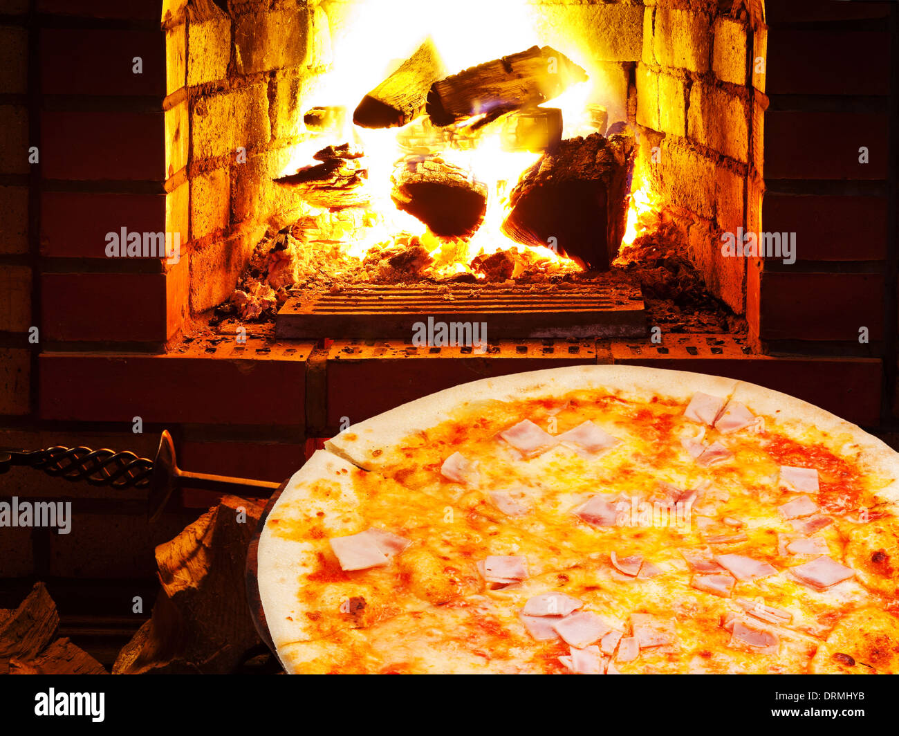italian pizza with prosciutto cotto and open fire in wood burning oven ...