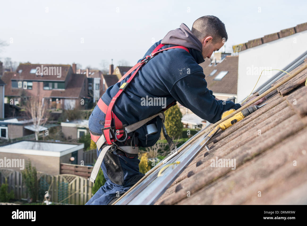 man making the construction for the solar panels high on the roof Stock ...