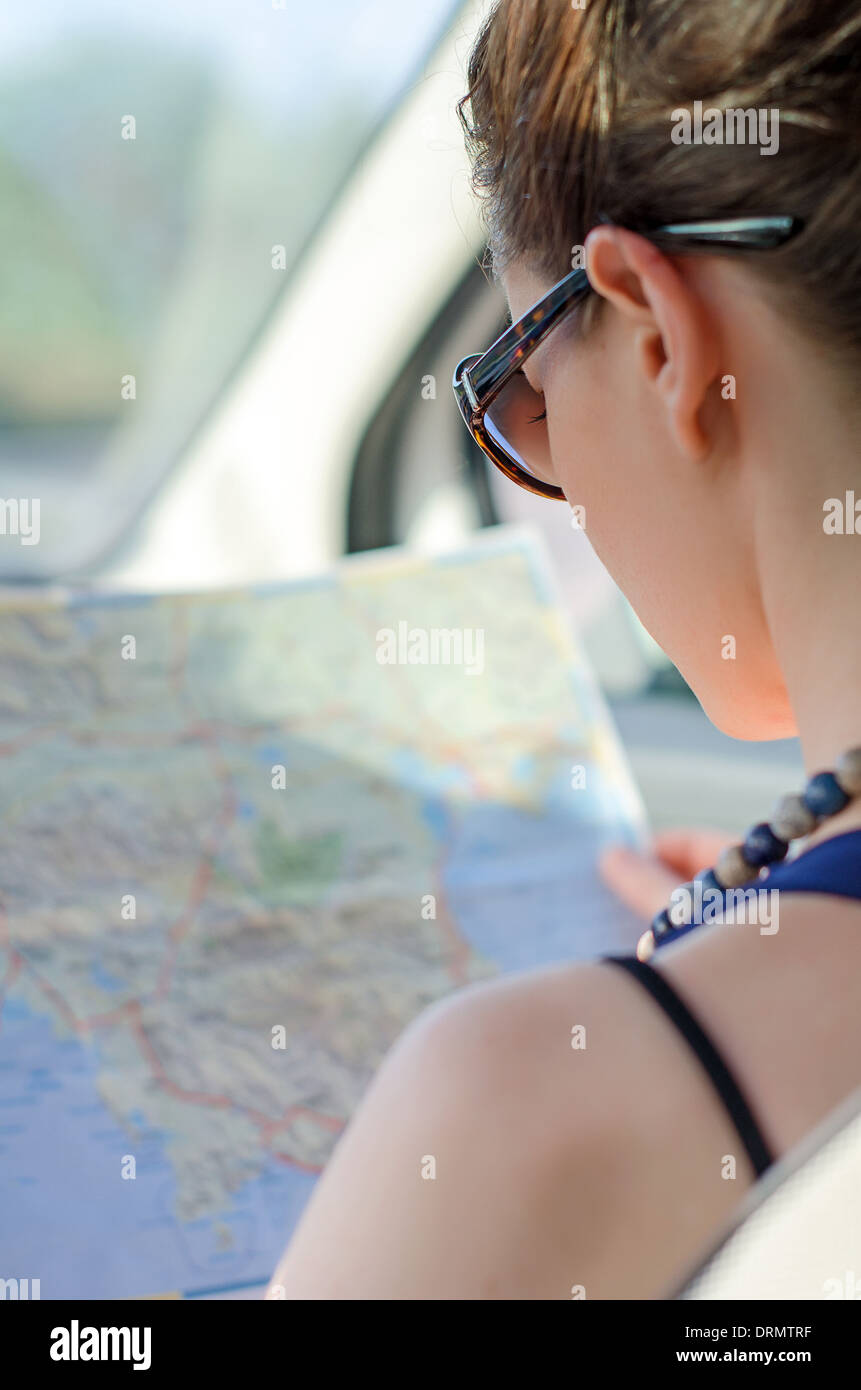 Female tourist looking at map in car Stock Photo - Alamy