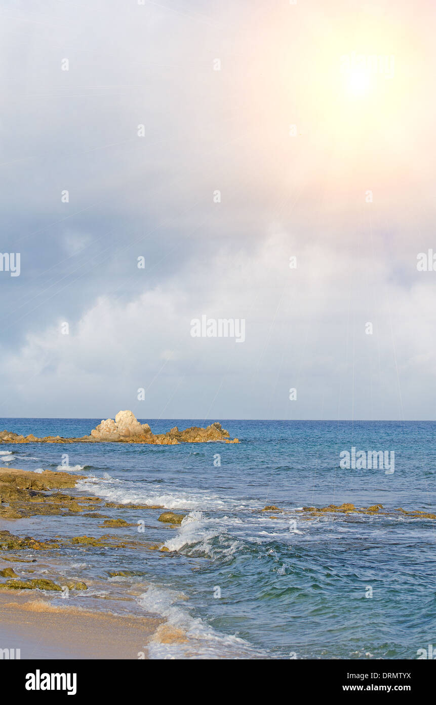 Sunny beach with rocks and blue sea Stock Photo - Alamy