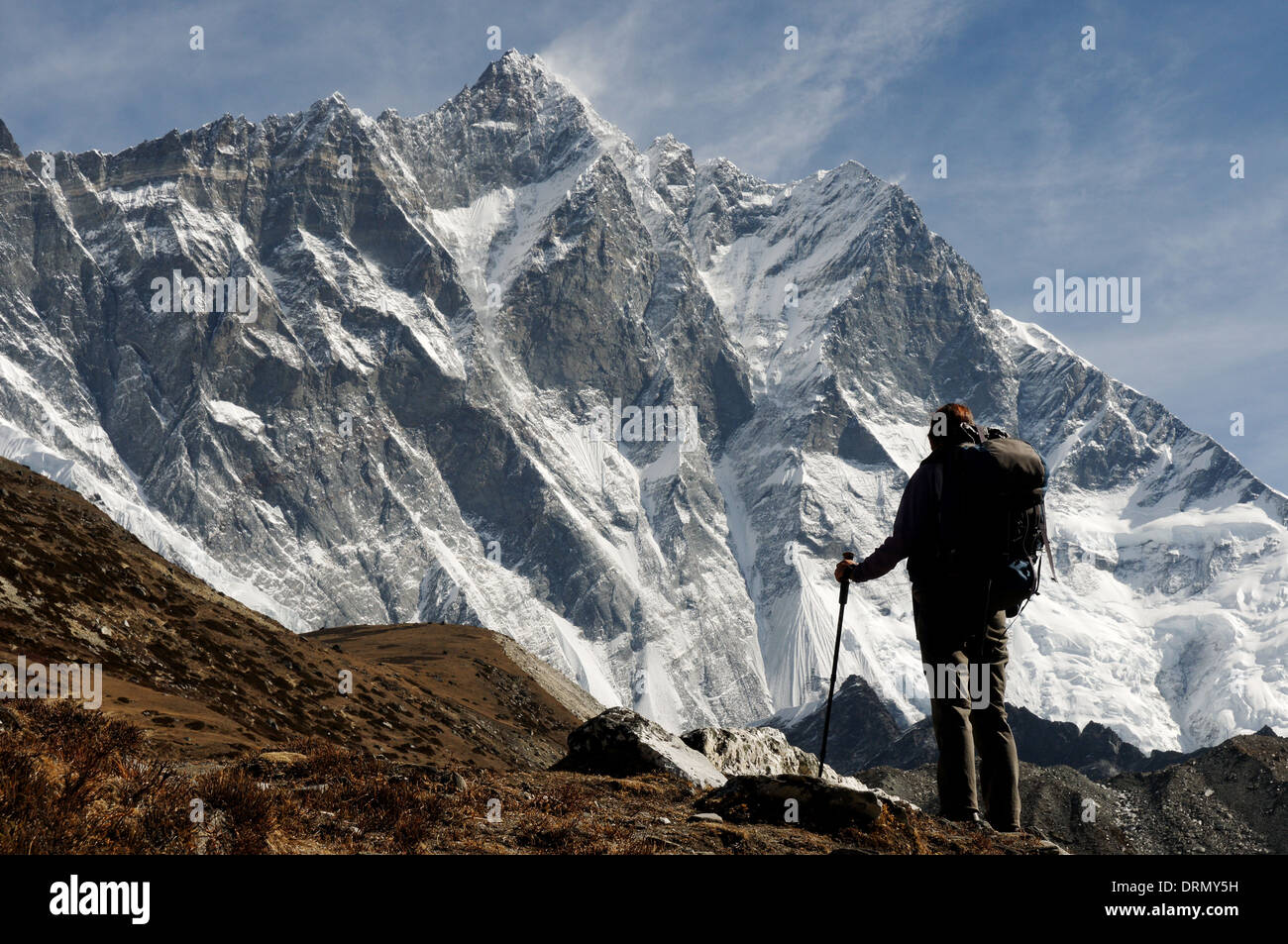 A lady trekker near Chukkung on the Everest Base Camp trek, the huge ...