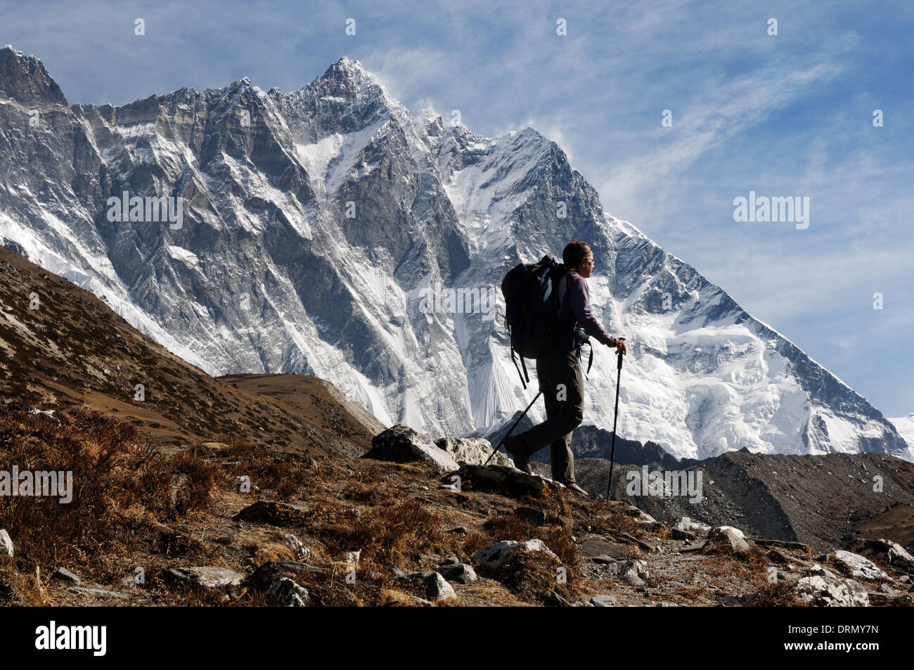 A lady trekker near Chukkung on the Everest Base Camp trek, the huge ...