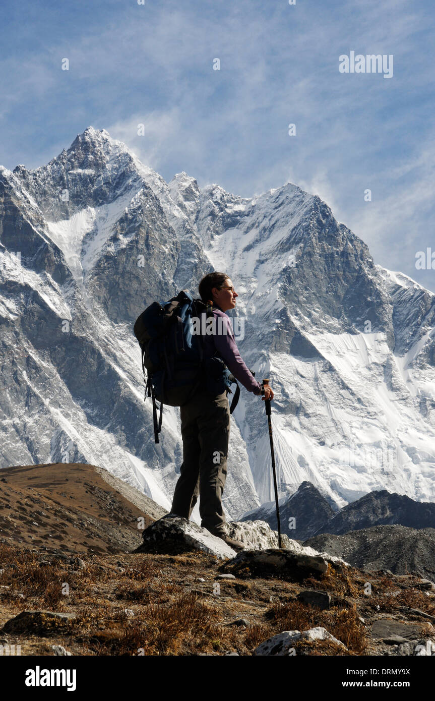 A lady trekker near Chukkung on the Everest Base Camp trek, the huge ...