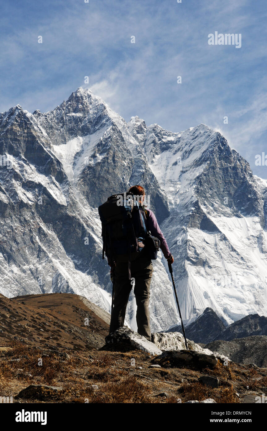 A lady trekker near Chukkung on the Everest Base Camp trek, the huge ...