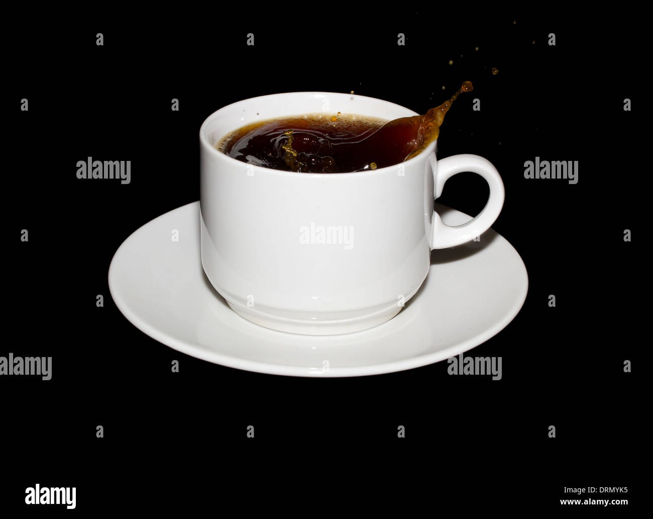 Sugar cube dropped into a cup of coffee isolated on a black background ...