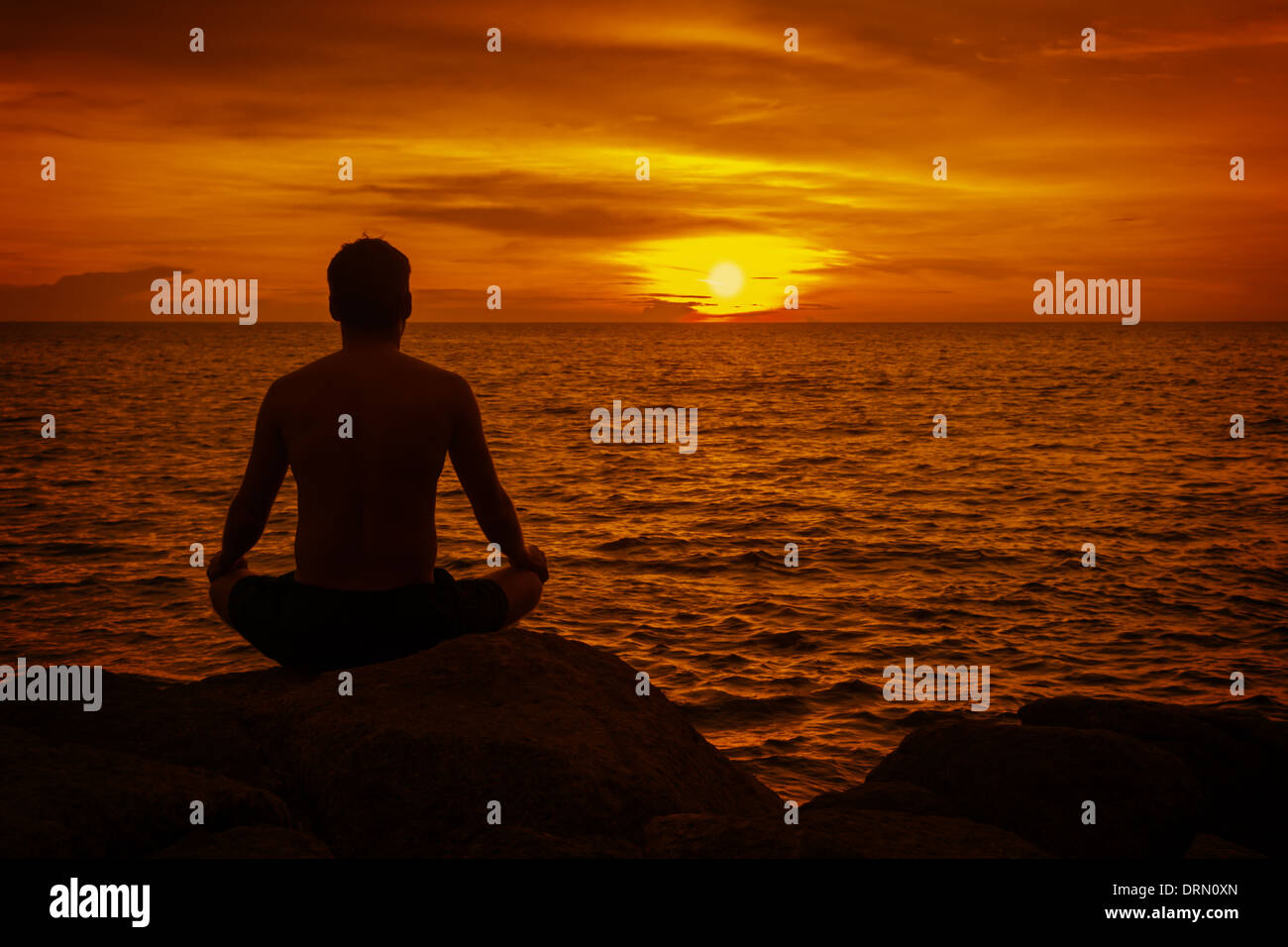 One man meditating sunset hi-res stock photography and images - Alamy