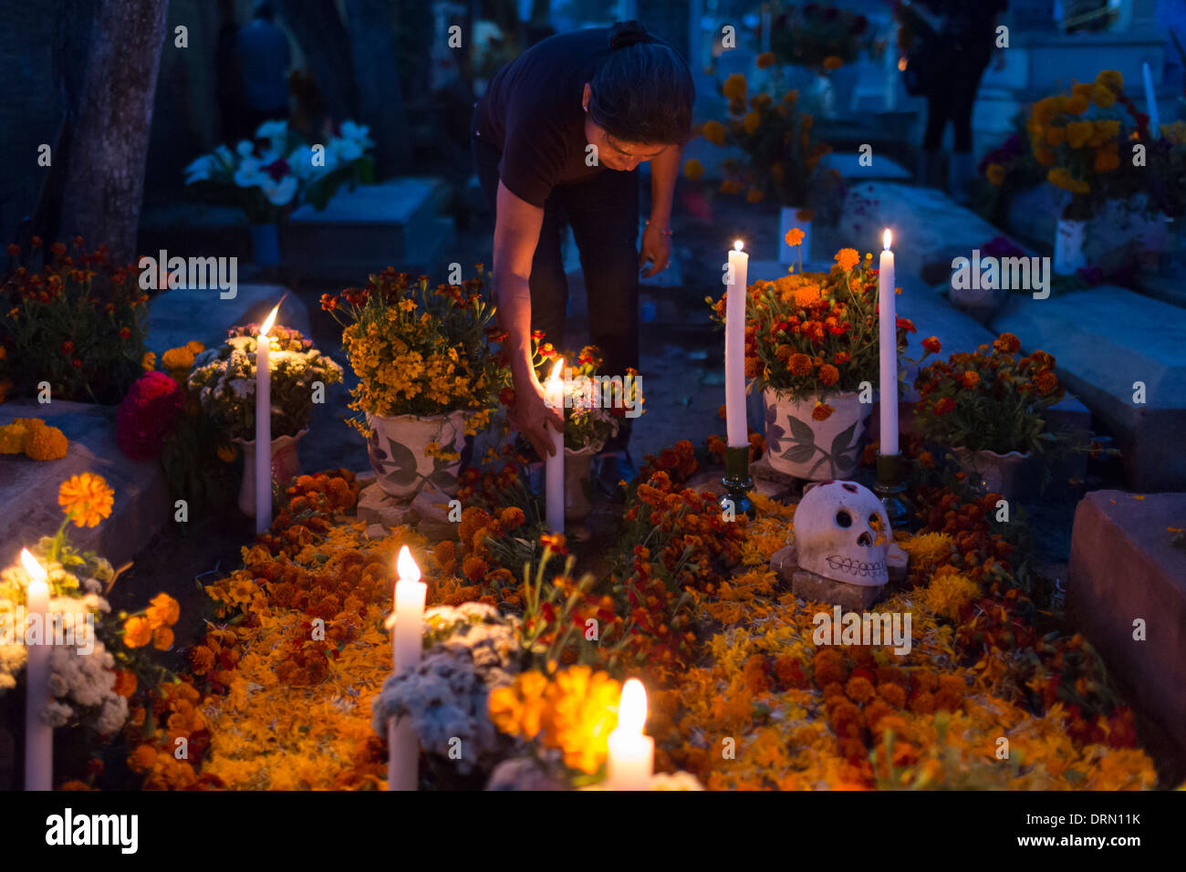A woman prepares decorating the tomb of one of their dead relatives ...