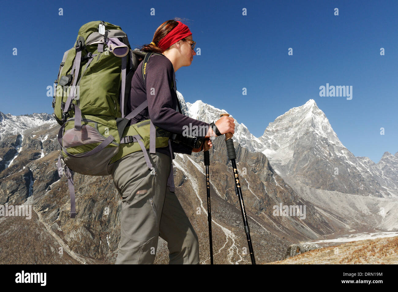 A lady trekker passes Cholatse and Taboche peaks on the Everest Base ...