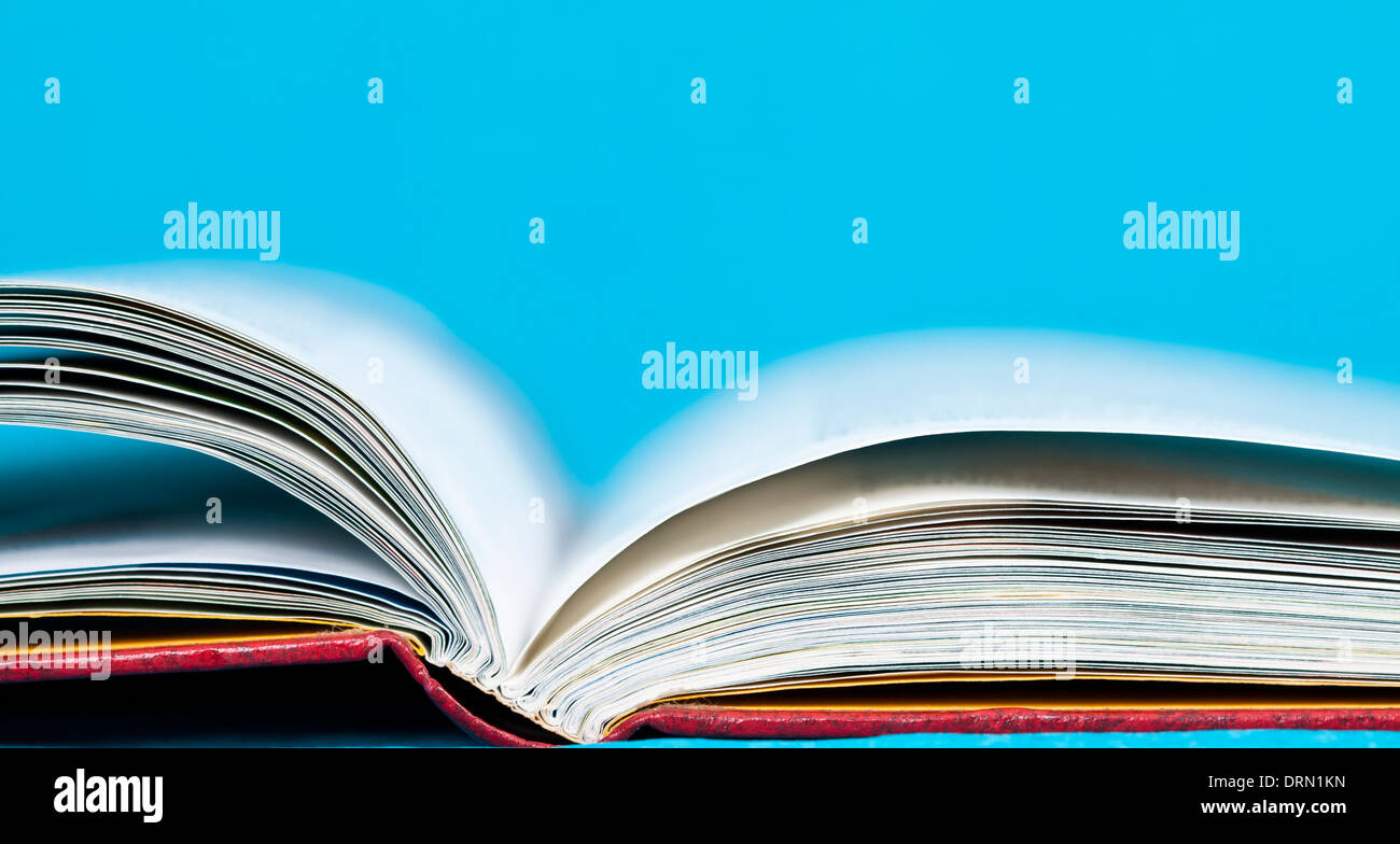 Open book in front of blue background Stock Photo - Alamy
