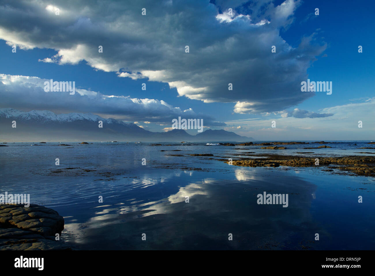 Seaward Kaikoura Ranges and clouds reflected in coastal tidal pools ...