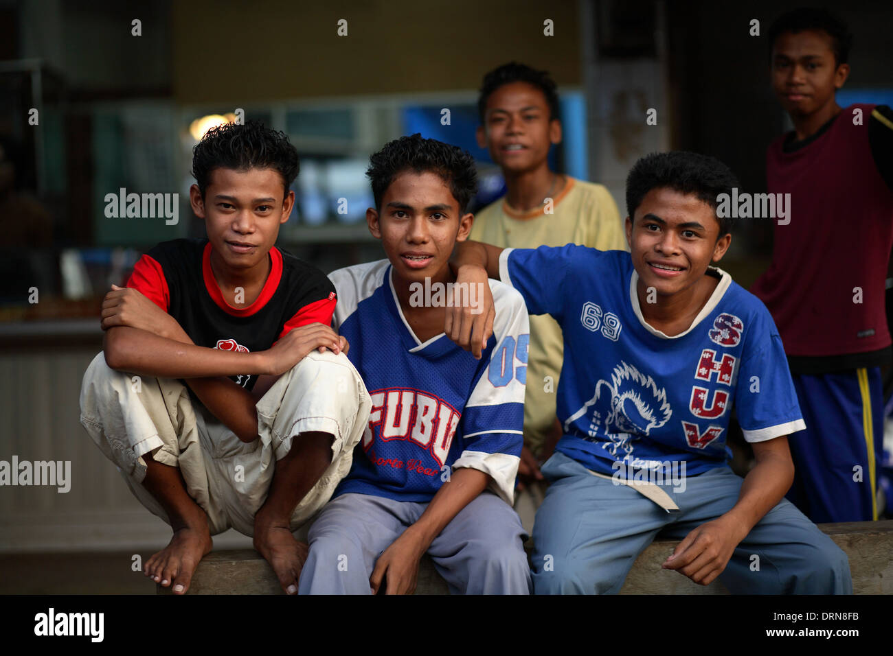 A group of teenage Indonesian boys hang out together at the market of ...