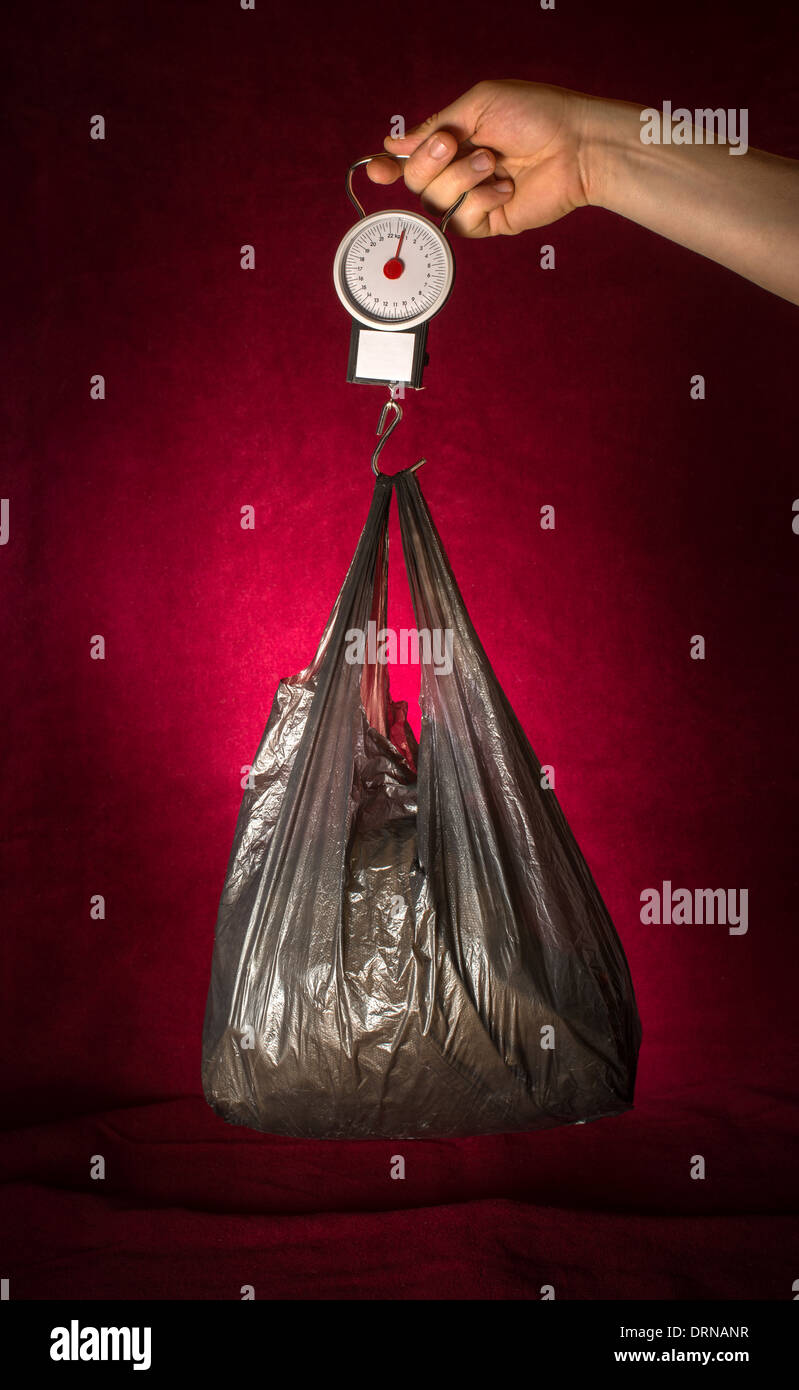 Weigh scales and bag on red background Stock Photo - Alamy