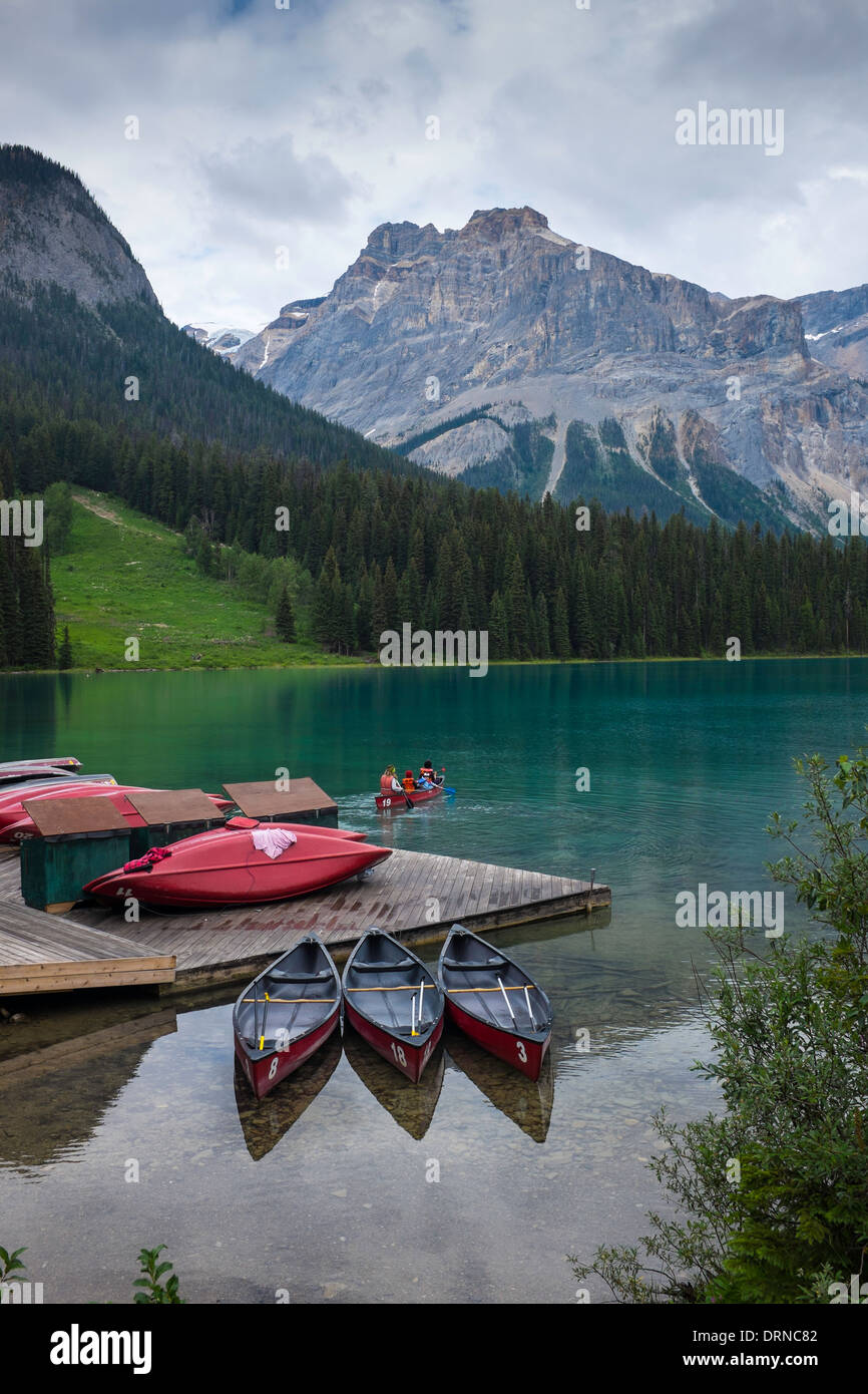 A couple paddle a kayak from the jetty out onto Emerald Lake, Yoho ...