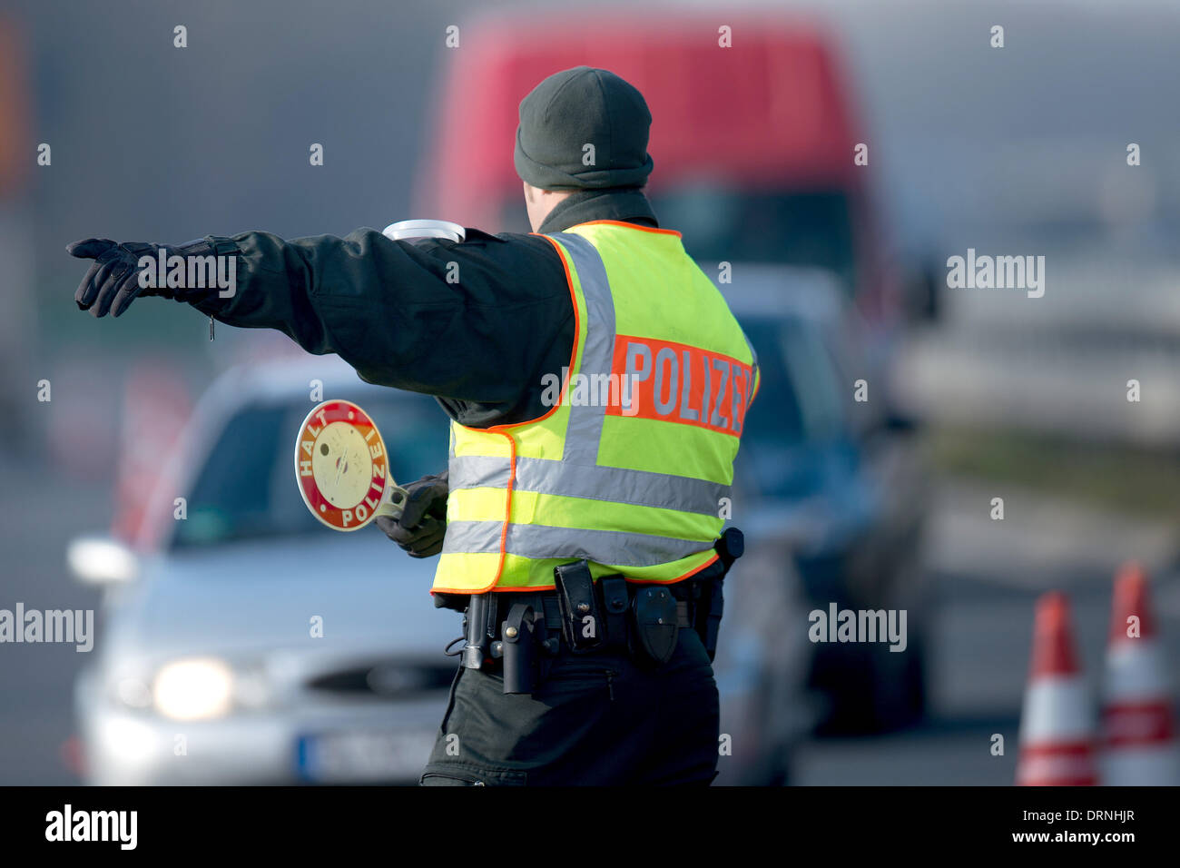 A police officer stops a car on the A52 Autobahn on the Dutch border ...