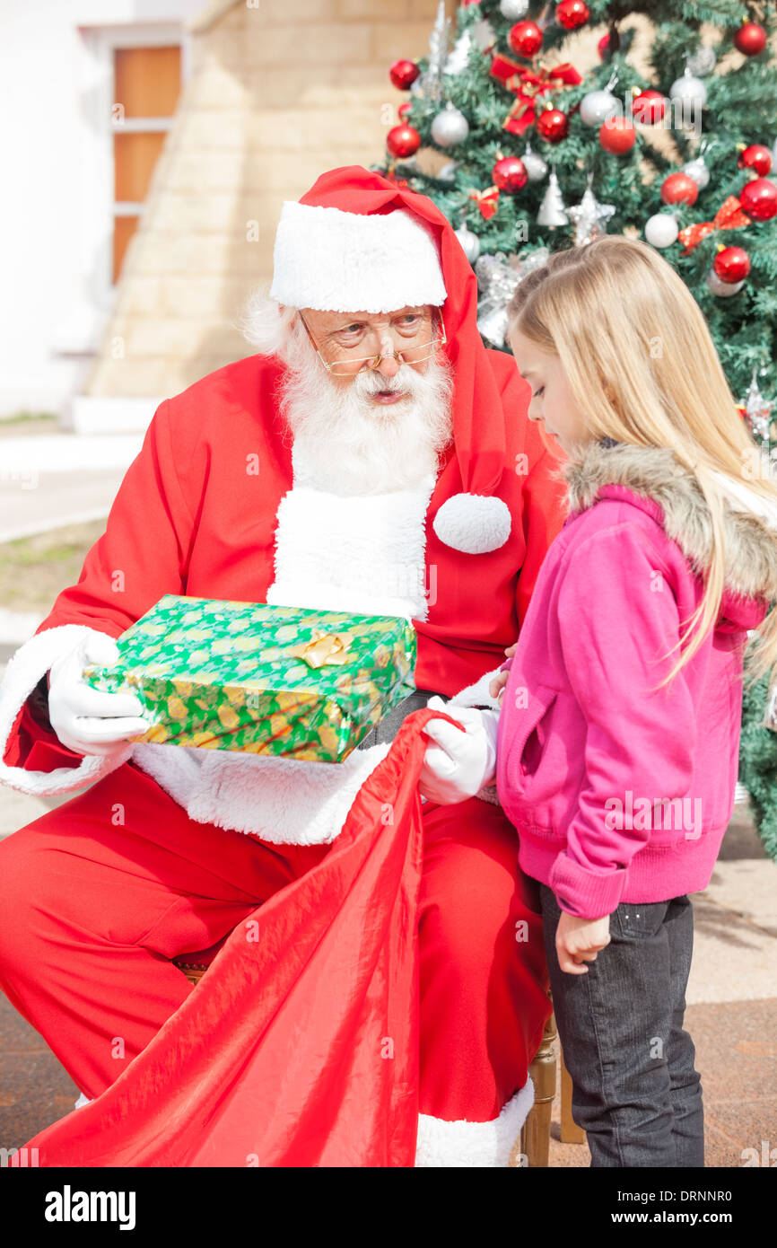 Santa Claus Giving Present To Girl Stock Photo - Alamy
