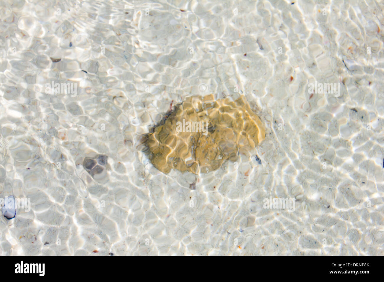 Blue water texture with small stones Stock Photo - Alamy