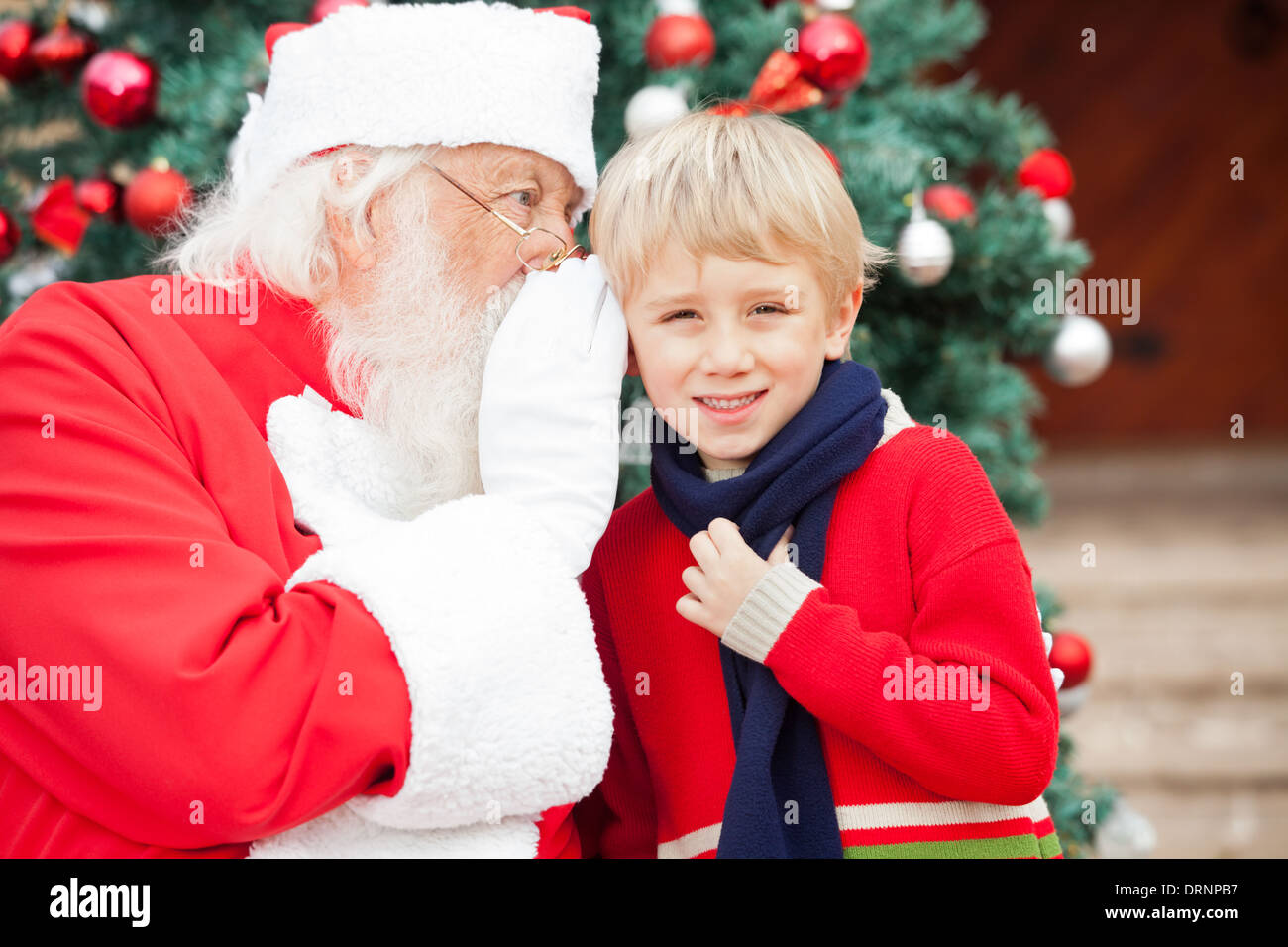 Santa Claus Whispering In Boy's Ear Stock Photo - Alamy