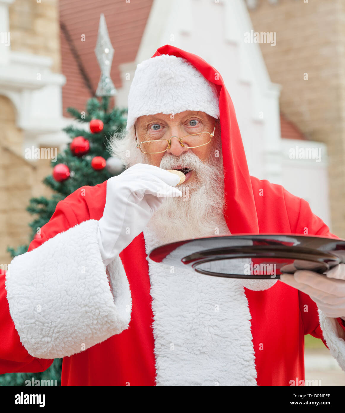 Santa Claus Eating Cookie Against House Stock Photo - Alamy