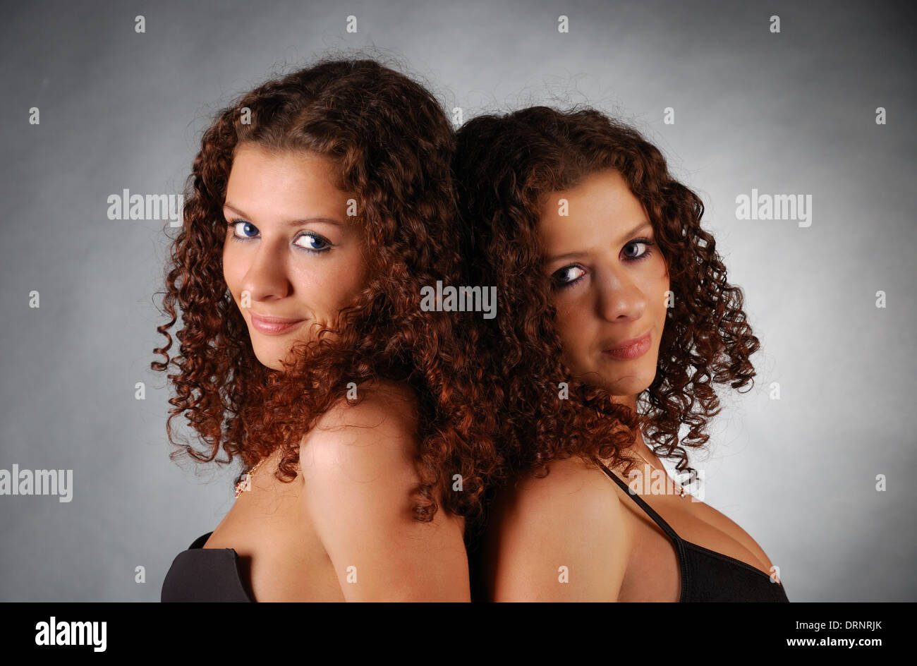 Portrait of twins back to back Stock Photo - Alamy