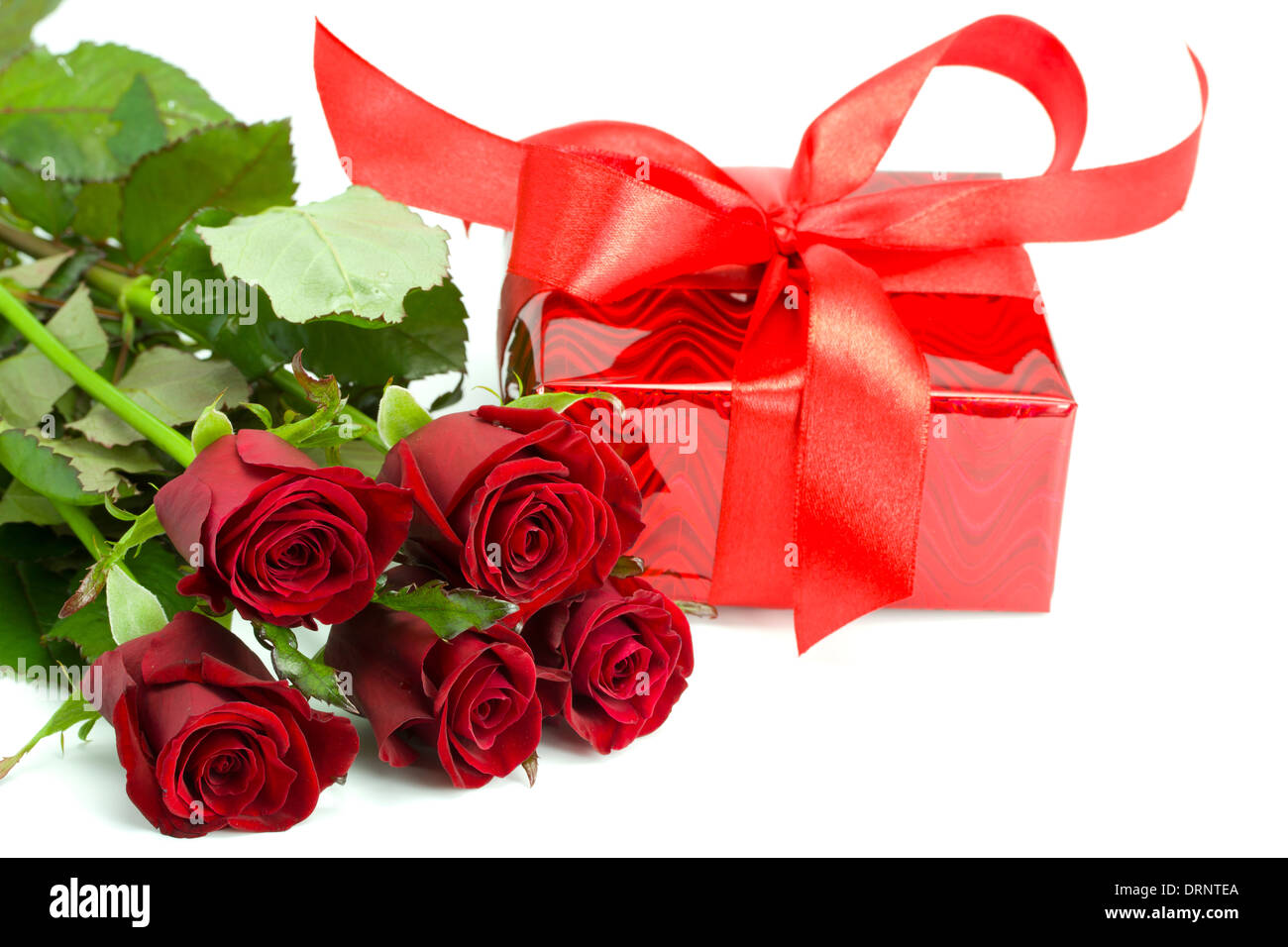 Bouquet of roses and red gift tied up by a bow on the white isolated ...