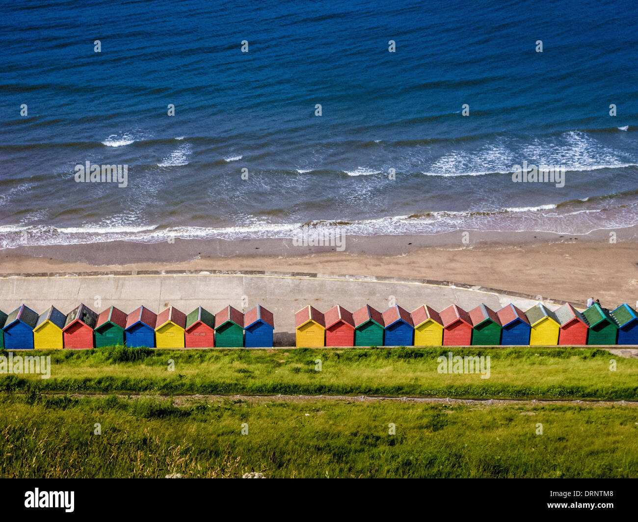 Colourful beach huts at the base of West Cliff, Whitby, North Yorkshire ...
