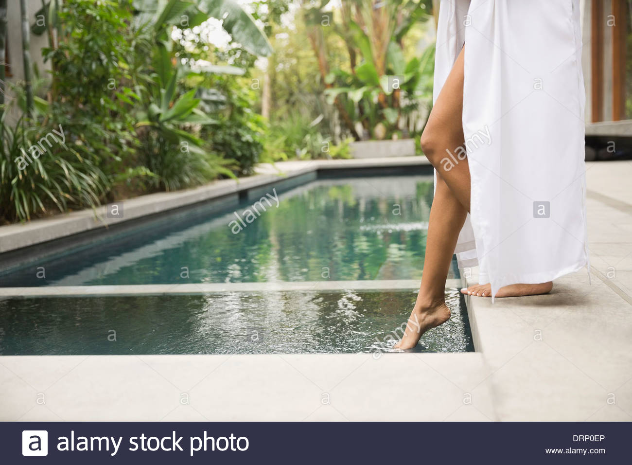 Woman dipping toe swimming pool hi-res stock photography and images - Alamy