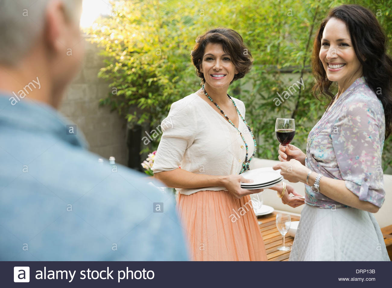 Women standing by dining table outdoors Stock Photo - Alamy