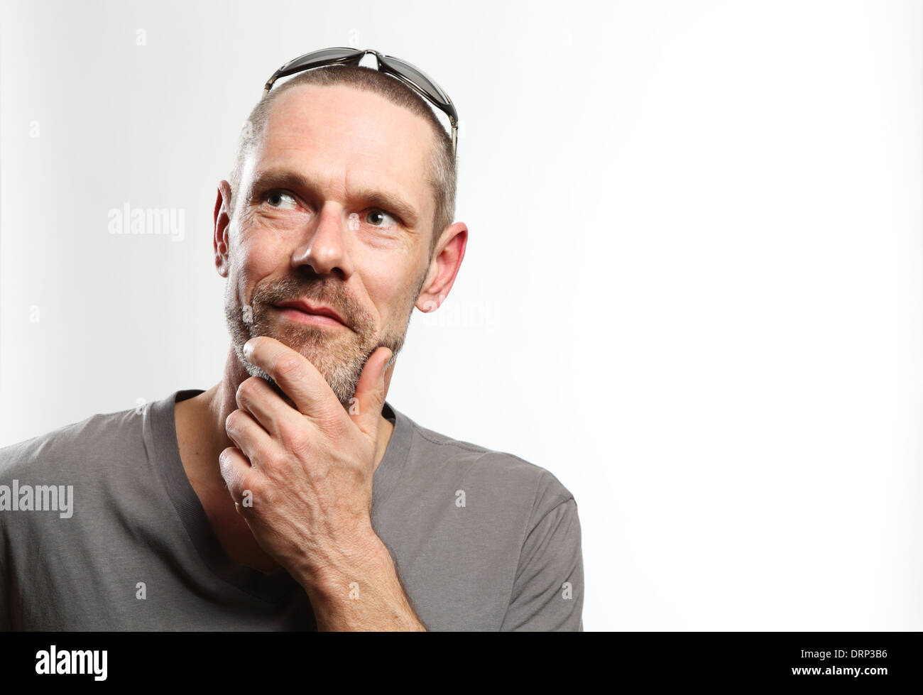 A simple portrait of a 40-something male with a soft smile looking off ...