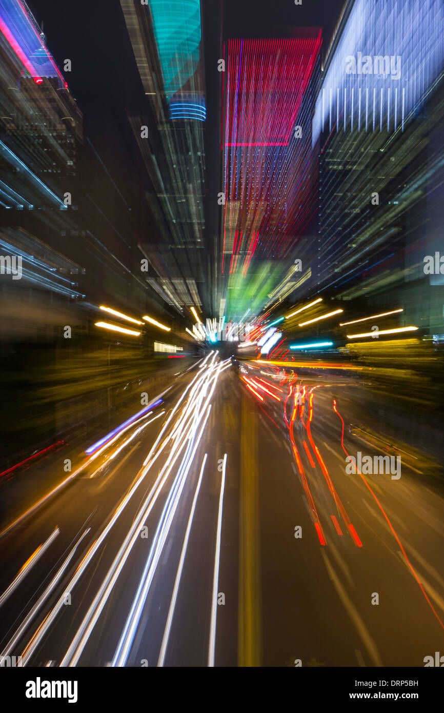 Abstract traffic lights and tall buildings at night in motion blur ...