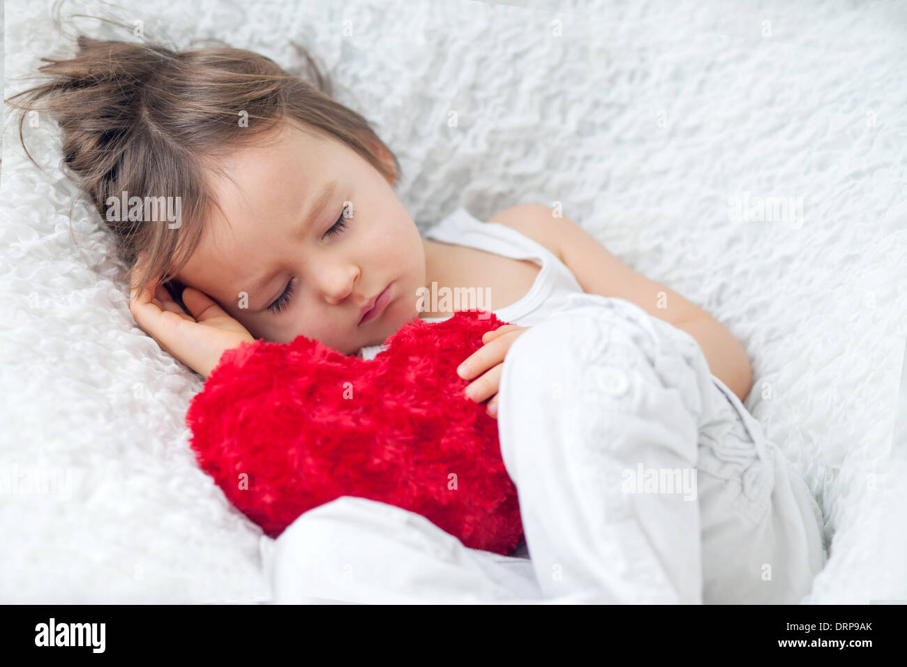 Little cute baby boy with a red heart, sleeping and resting Stock Photo ...