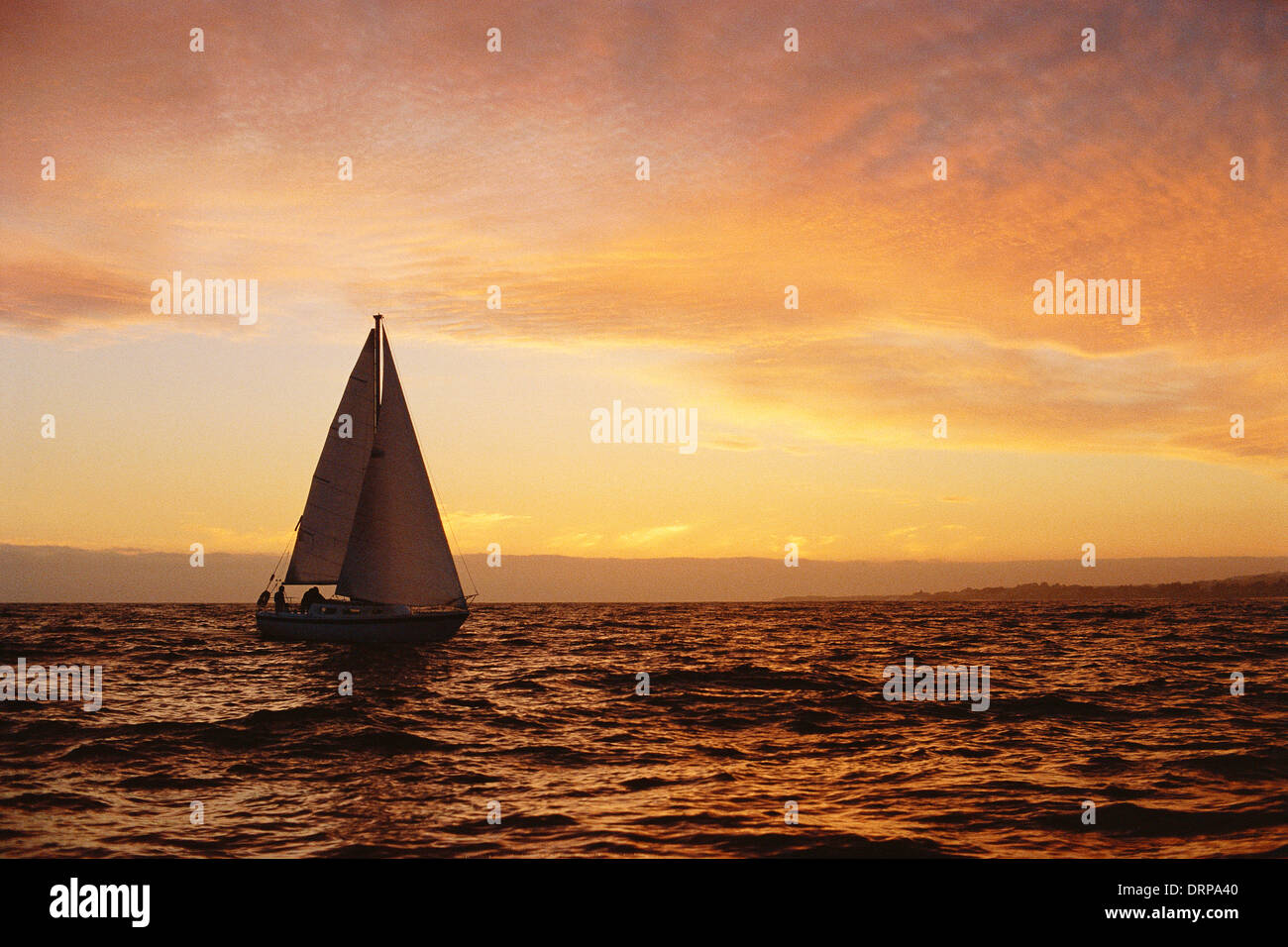 Sailboat sailing into a Pacific Ocean sunset Stock Photo - Alamy