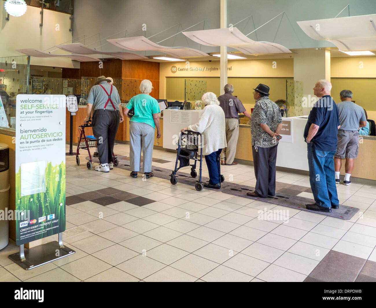 Elderly incoming patients line up to check in at the reception desk of ...