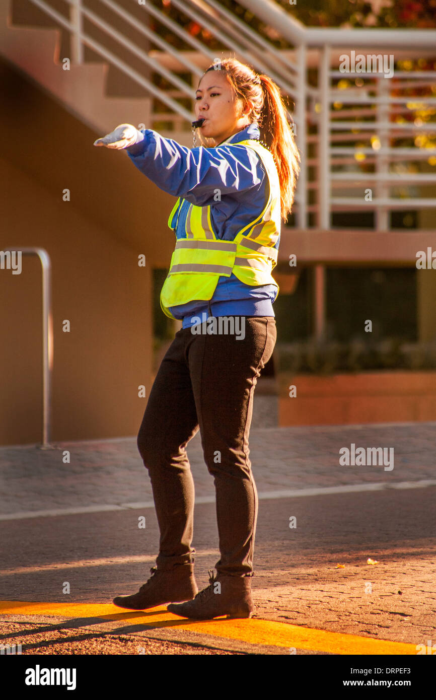An Asian American police officer directs traffic on the campus of the ...