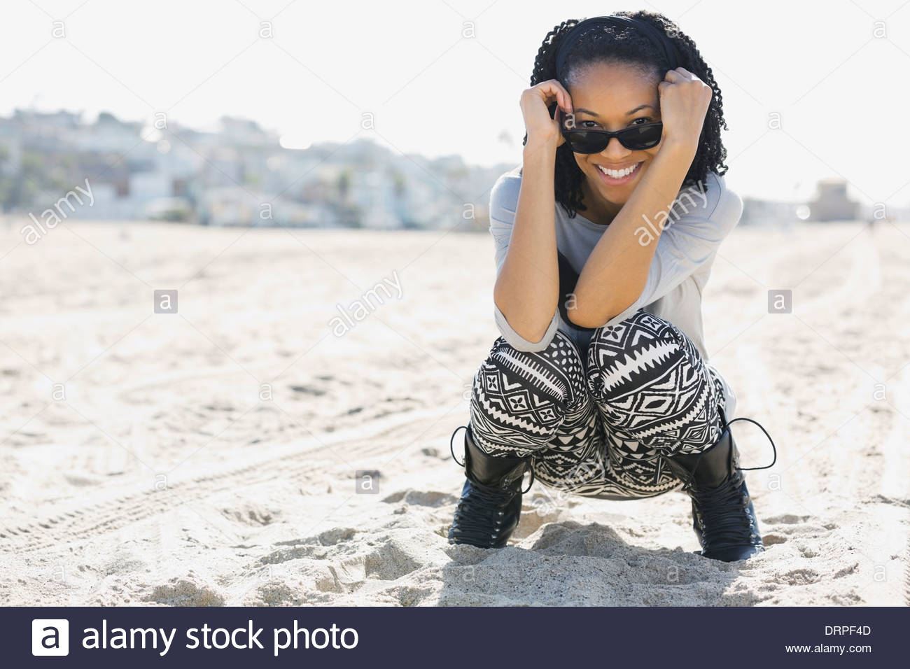 Young woman crouching on the beach hi-res stock photography and images ...
