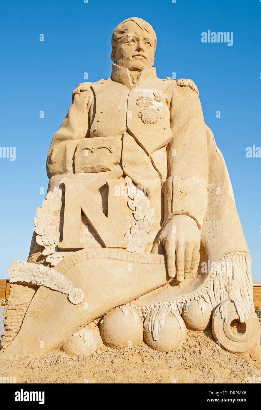 Large sand sculpture statue of emperor napoleon bonaparte against blue ...