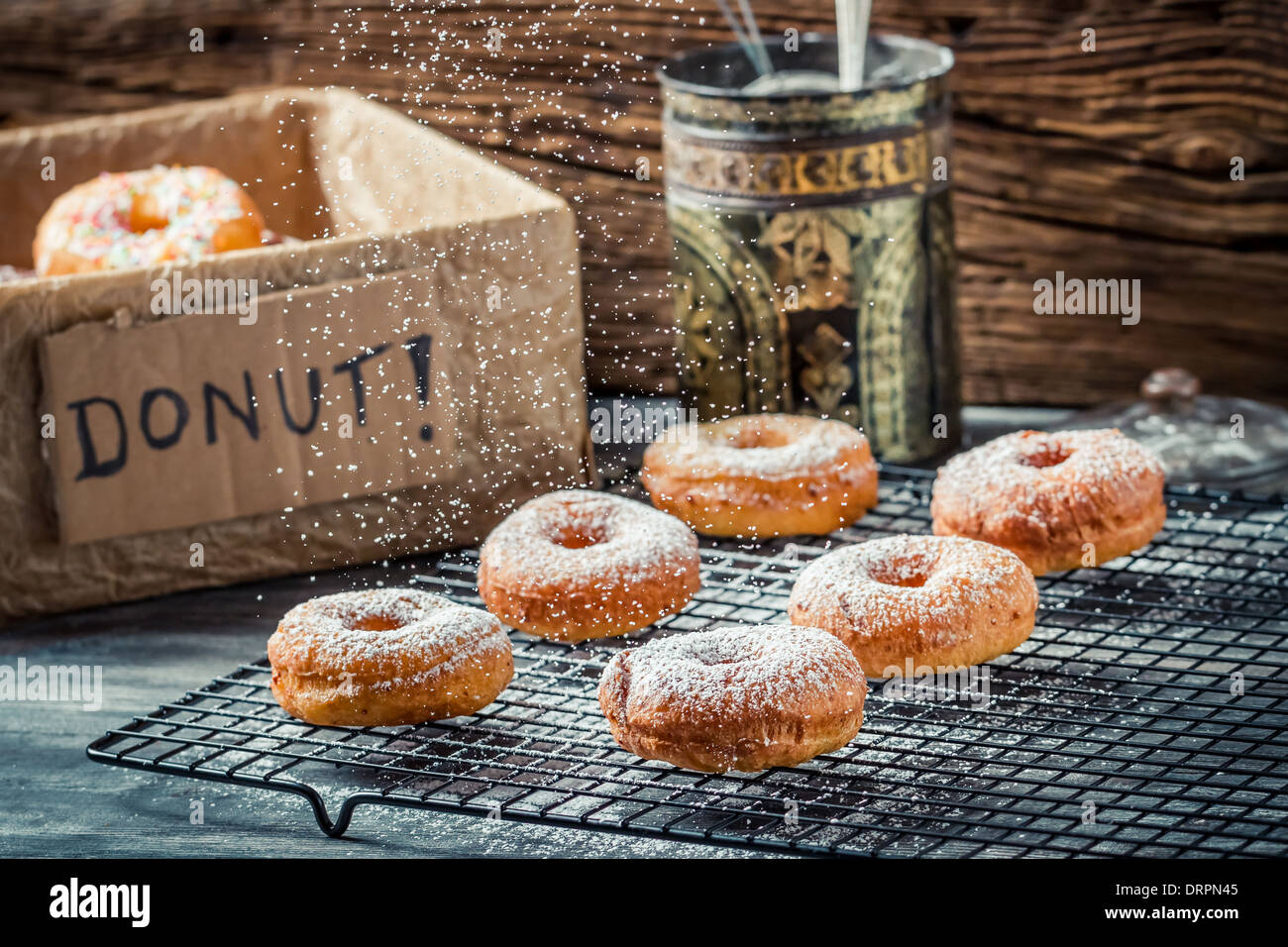 Icing sugar falling on fresh donuts Stock Photo - Alamy