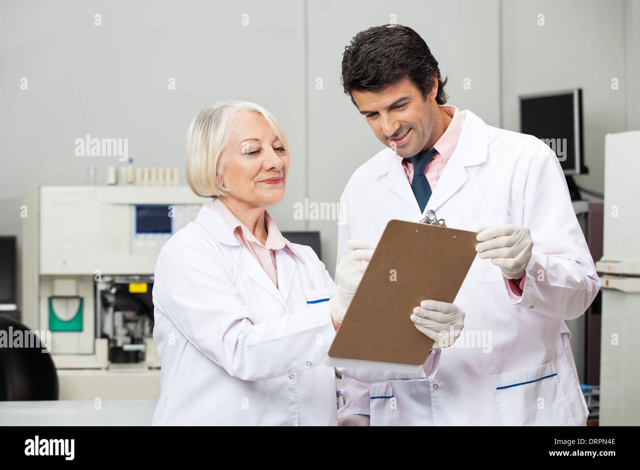 Scientists Writing On Clipboard In Laboratory Stock Photo - Alamy