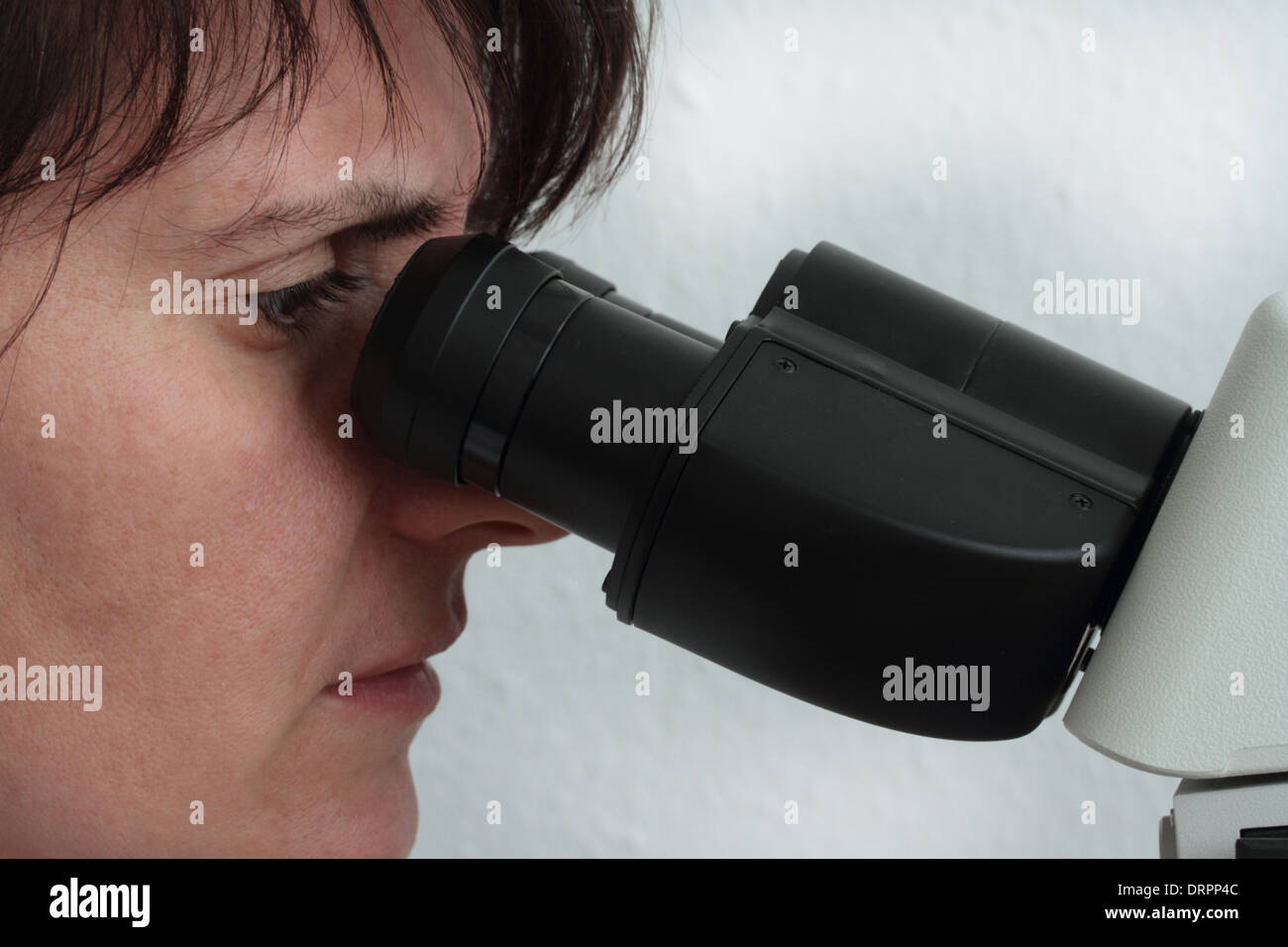young woman watching in light microscope Stock Photo - Alamy